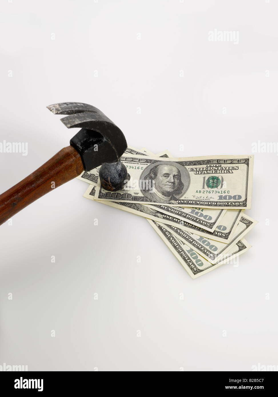 hammer pounding American dollar bills on white background Stock Photo ...