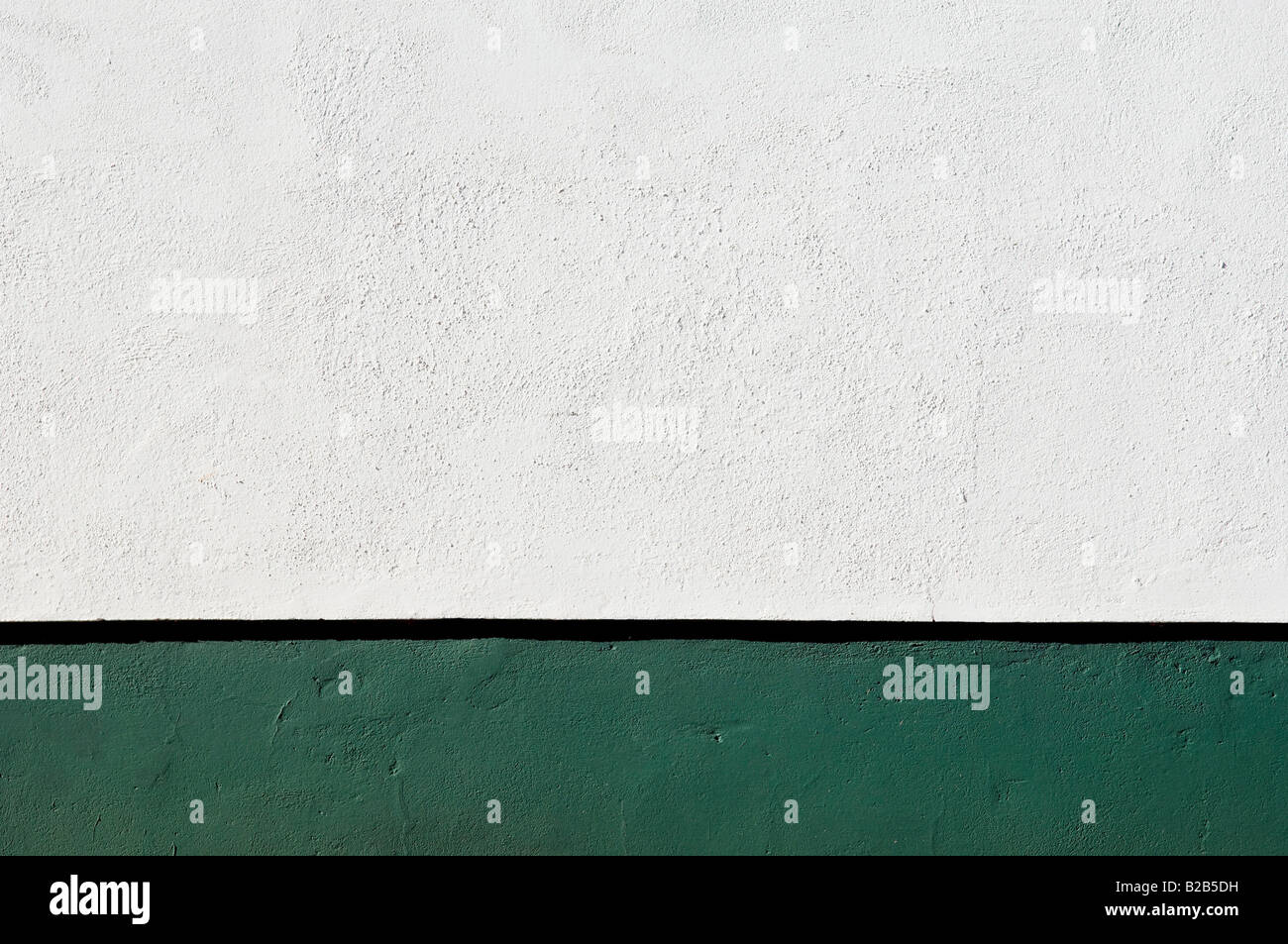 Detail of white wall with a nice deep green baseboard Stock Photo - Alamy