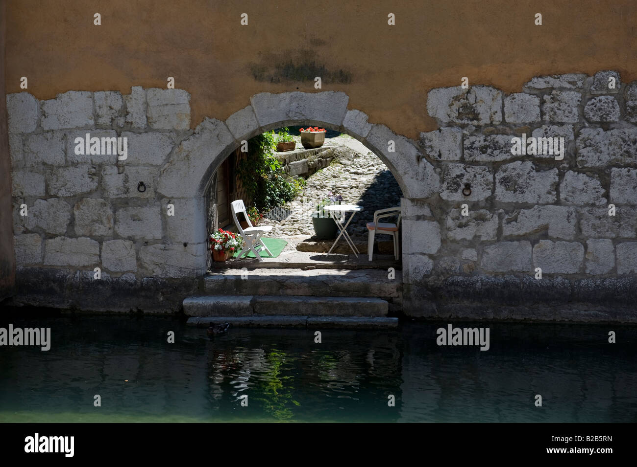 picnic table and chairs seen through archway in medieval Annecy, Haute ...