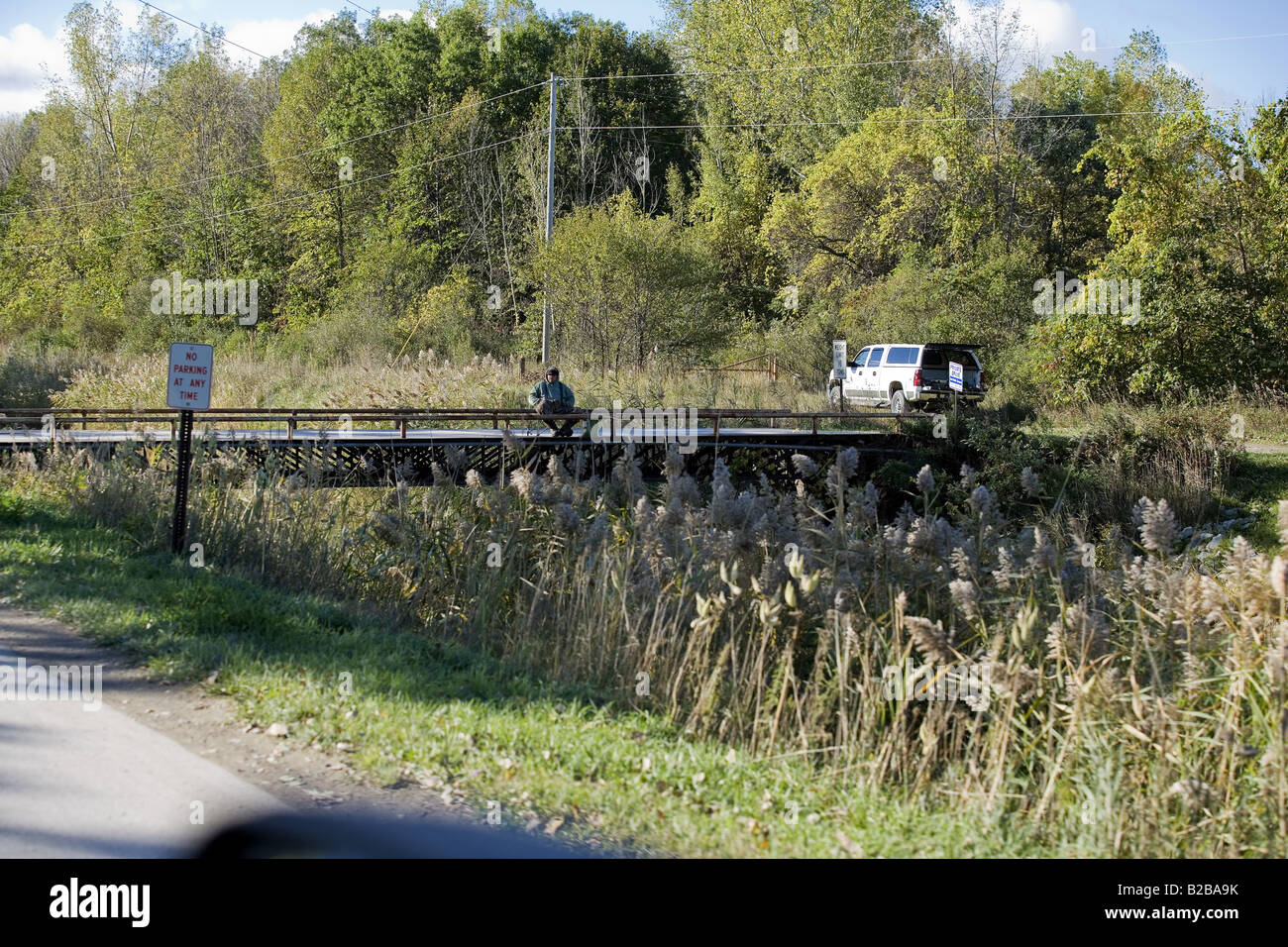 Man seated on edge or rural bridge Stock Photo - Alamy