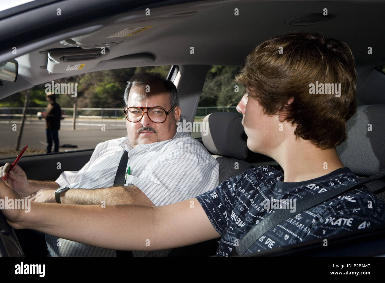 Driving instructor with teen taking driving test Stock Photo - Alamy