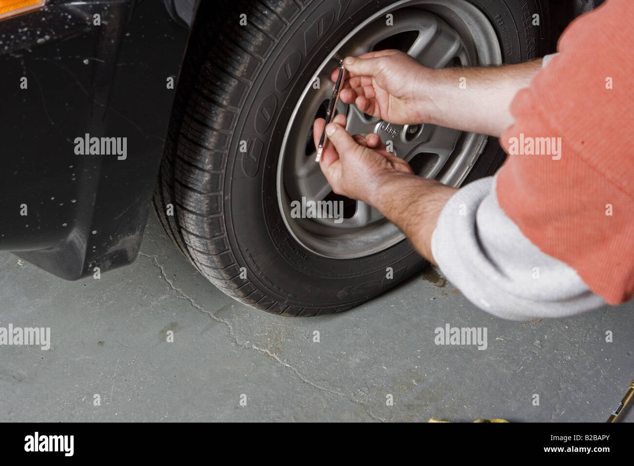 Auto mechanic checking tires with gauge Stock Photo - Alamy
