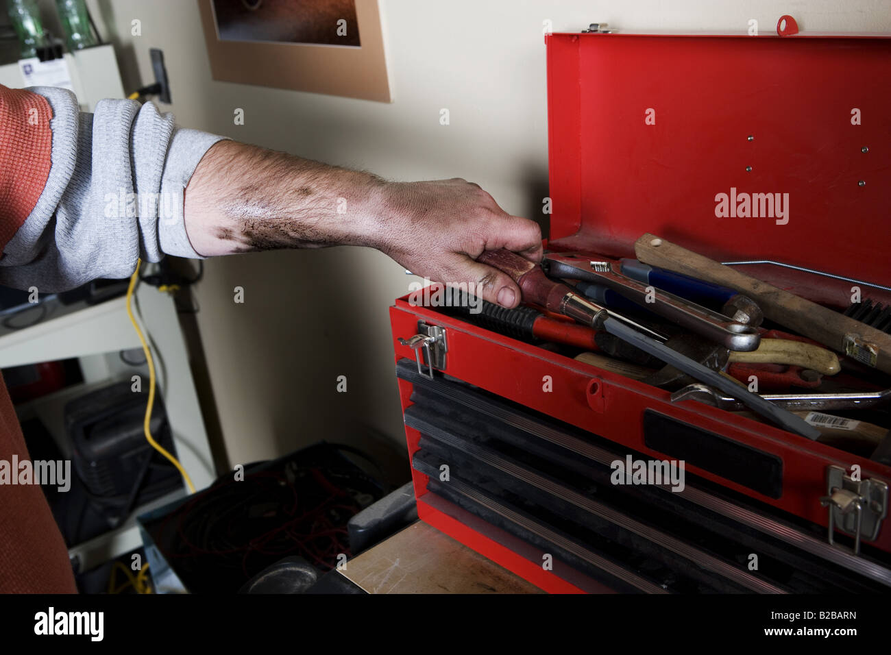 Auto mechanic picking up screwdriver from tool box Stock Photo - Alamy