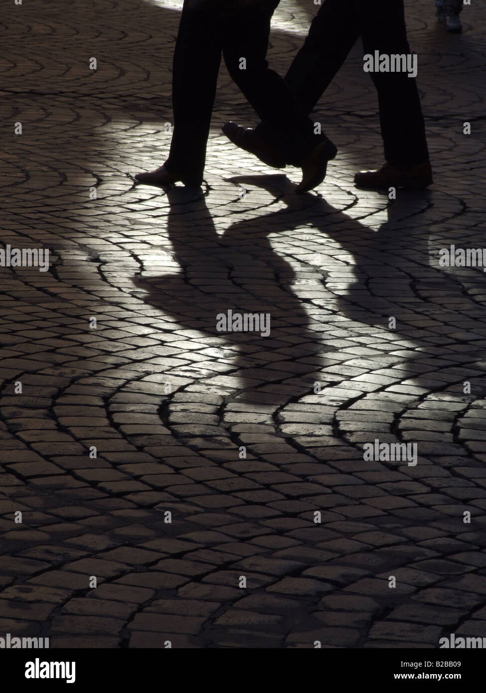 couple walking shadow on pavement street road Stock Photo - Alamy