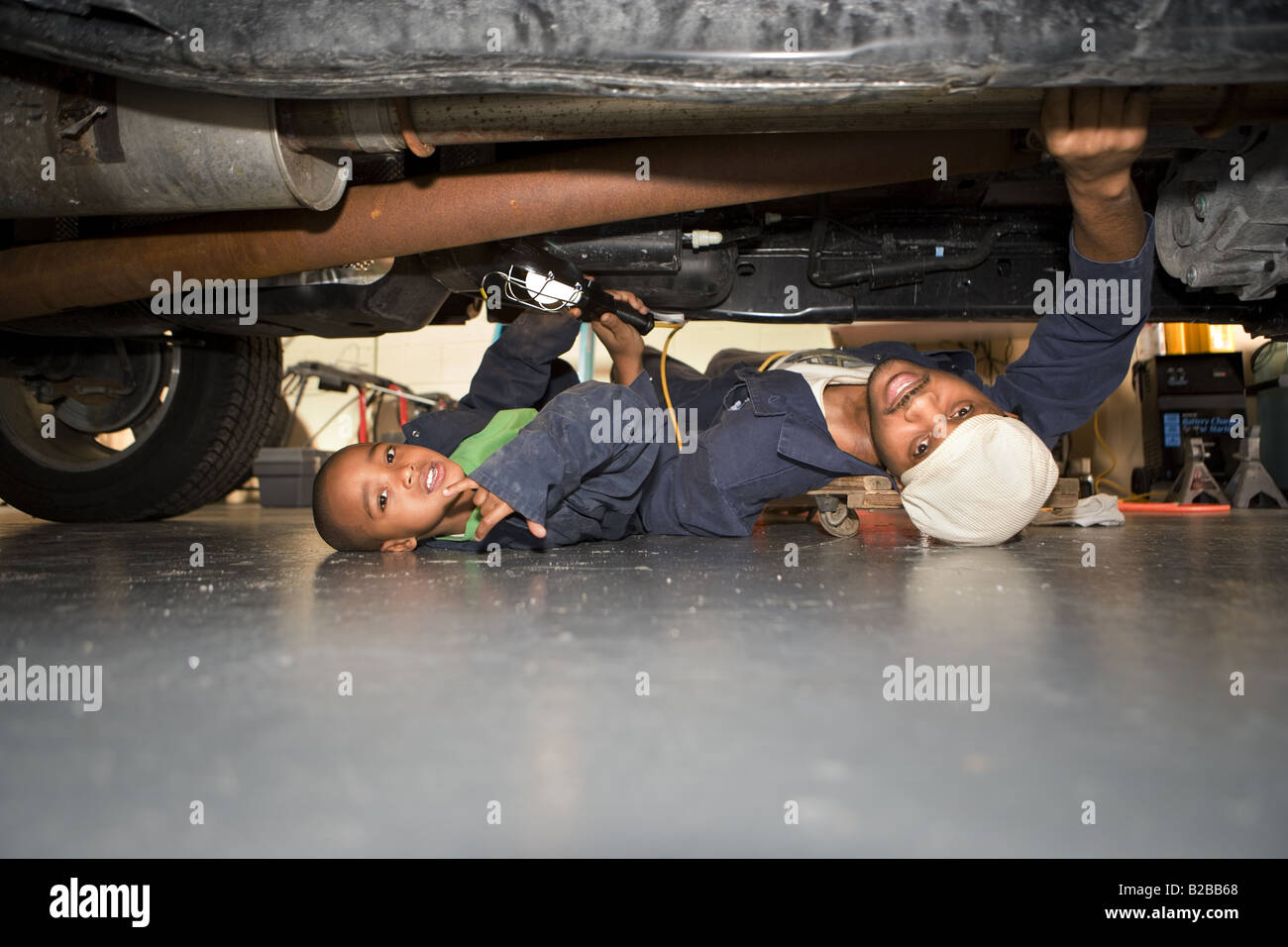 Man inspects his wife's greasy jeans in garage Stock Photo - Alamy