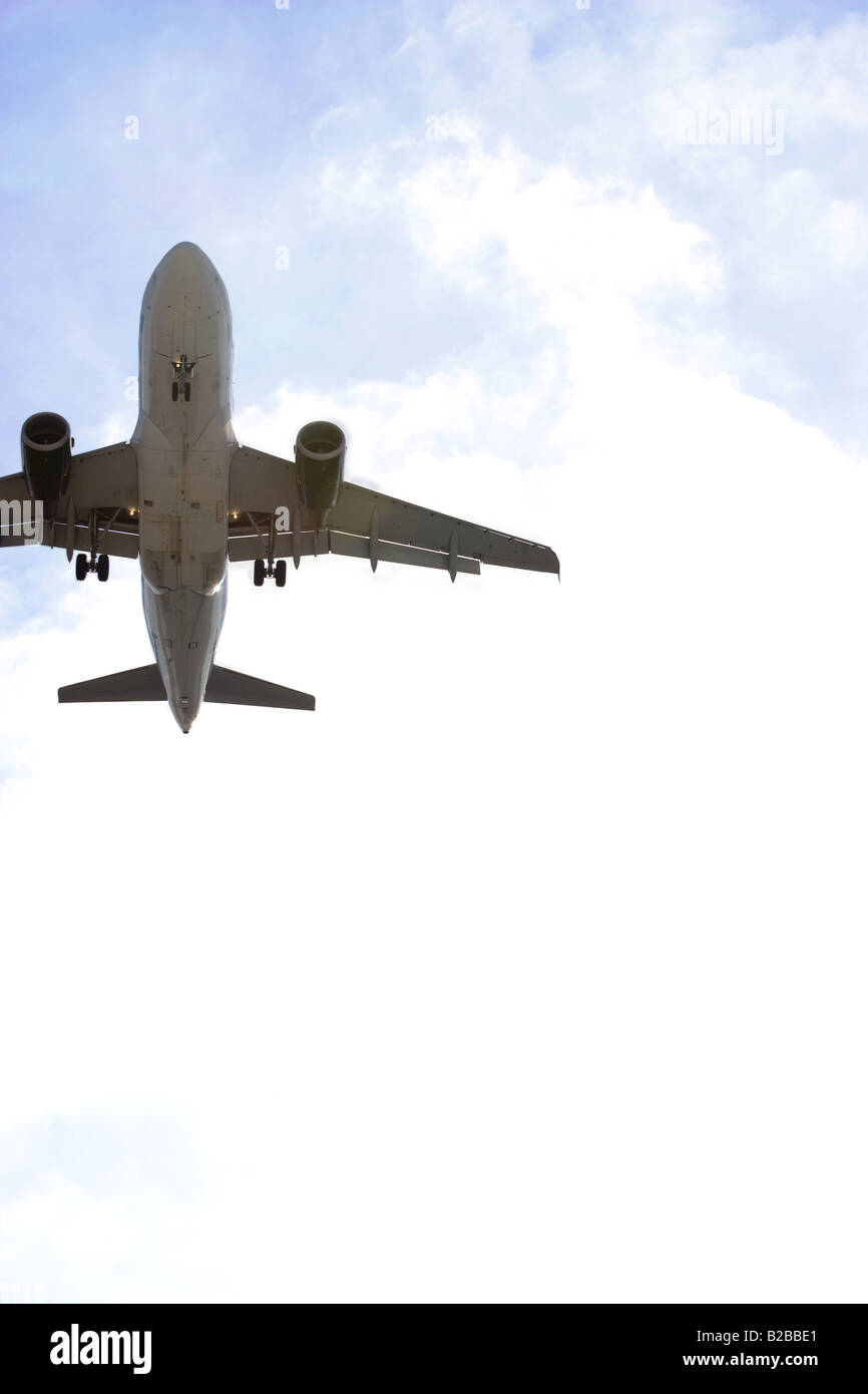 Airplane flying overhead preparing to land at airport Stock Photo - Alamy