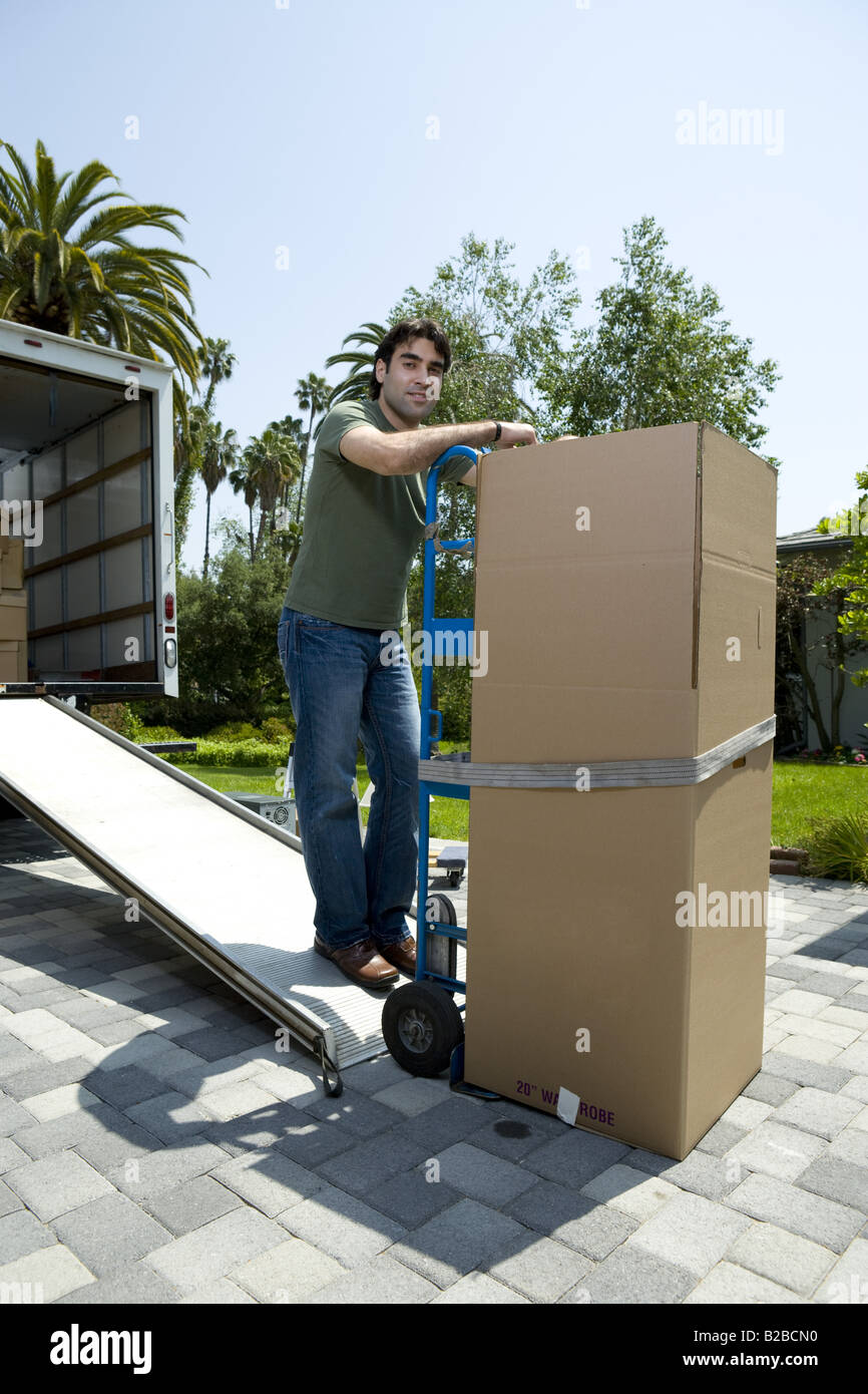 Young man moving box out of moving truck Stock Photo - Alamy