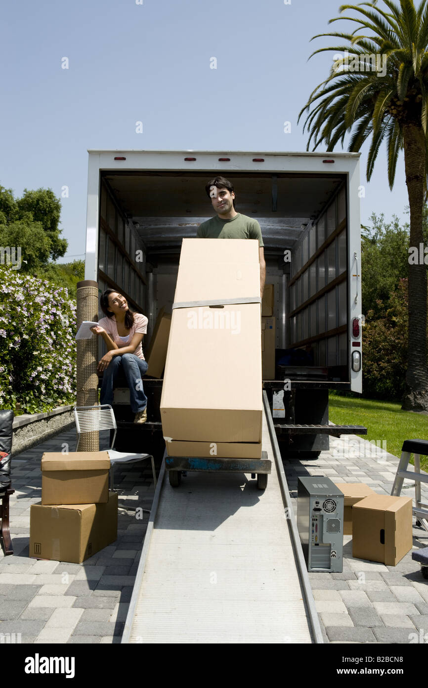 Young couple moving boxes out of moving truck Stock Photo - Alamy