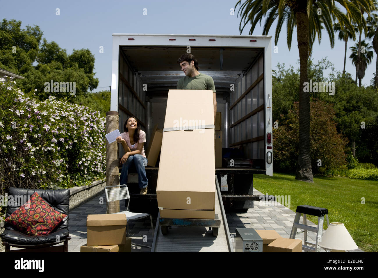 Young couple moving boxes out of moving truck Stock Photo - Alamy