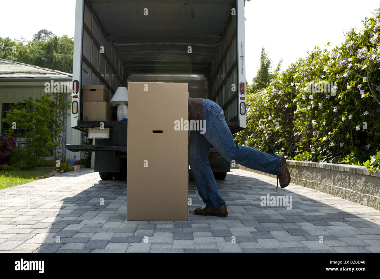 Young man climbing into large moving box Stock Photo - Alamy