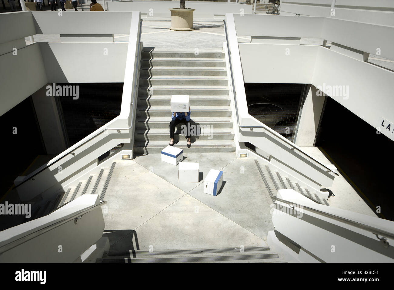 Businesswoman sitting on steps by dropped boxes of paperwork Stock ...