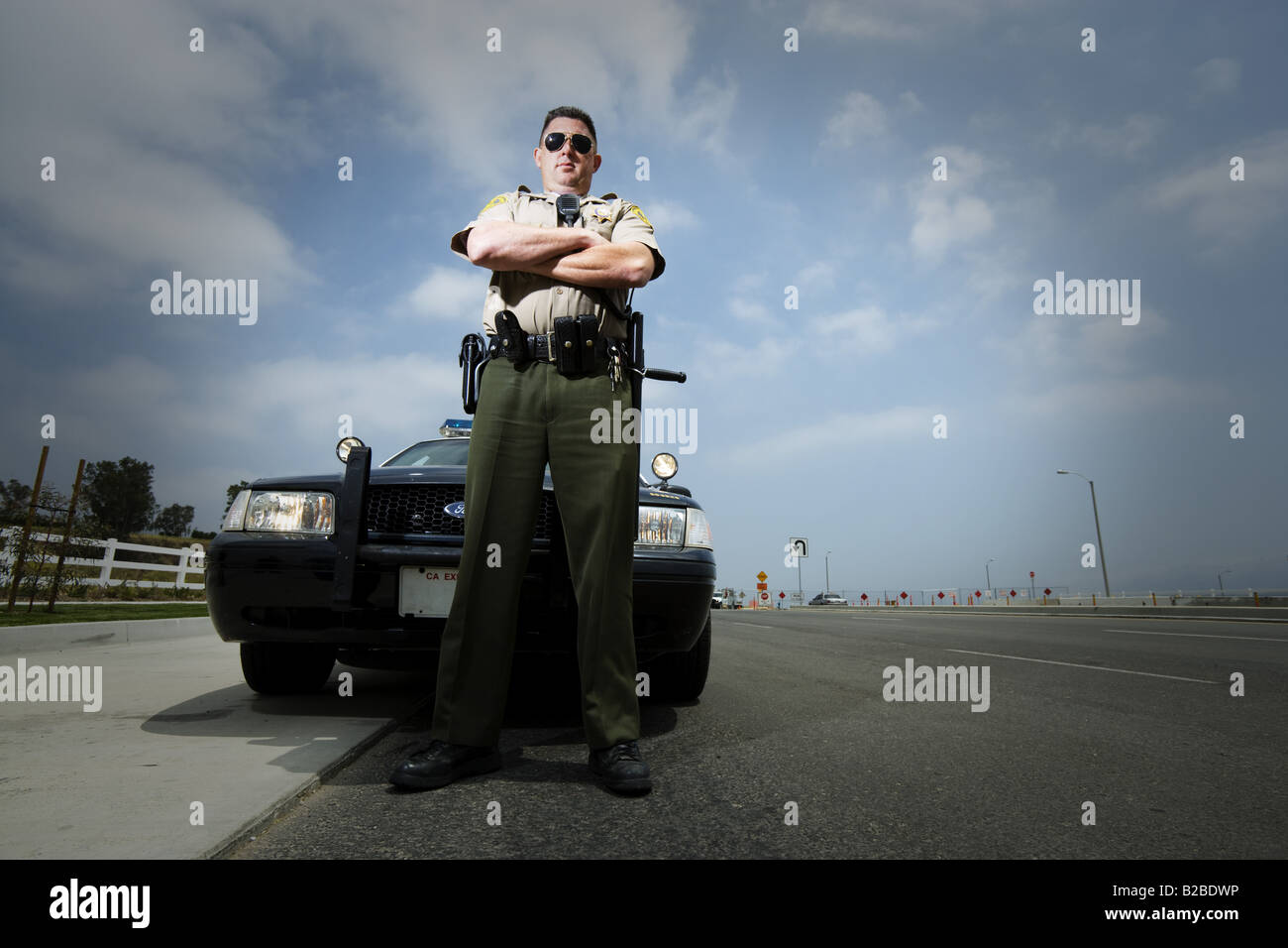 Police officer standing in front of police car Stock Photo - Alamy