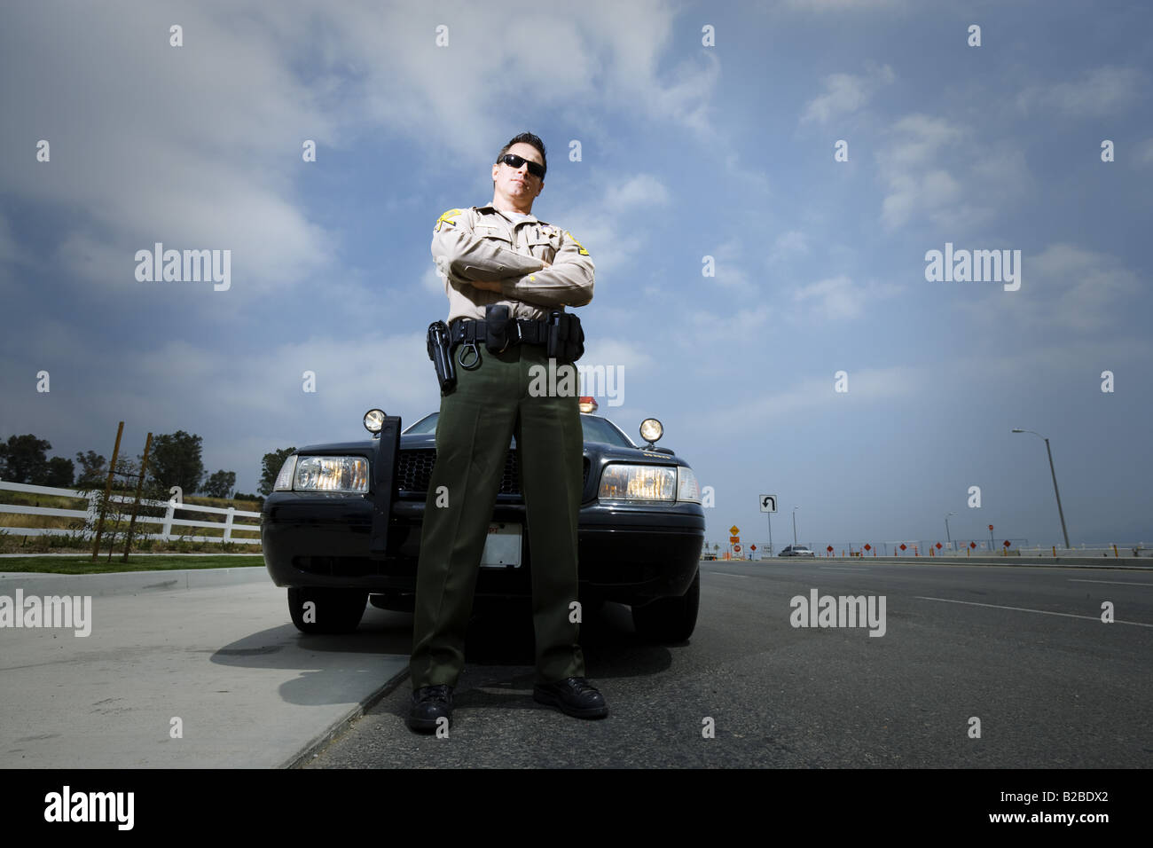 Police officer standing in front of police car Stock Photo - Alamy