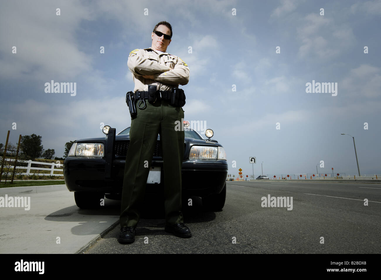 Police officer standing in front of police car Stock Photo - Alamy