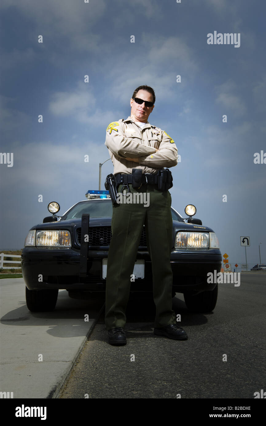Police officer standing in front of police car Stock Photo - Alamy
