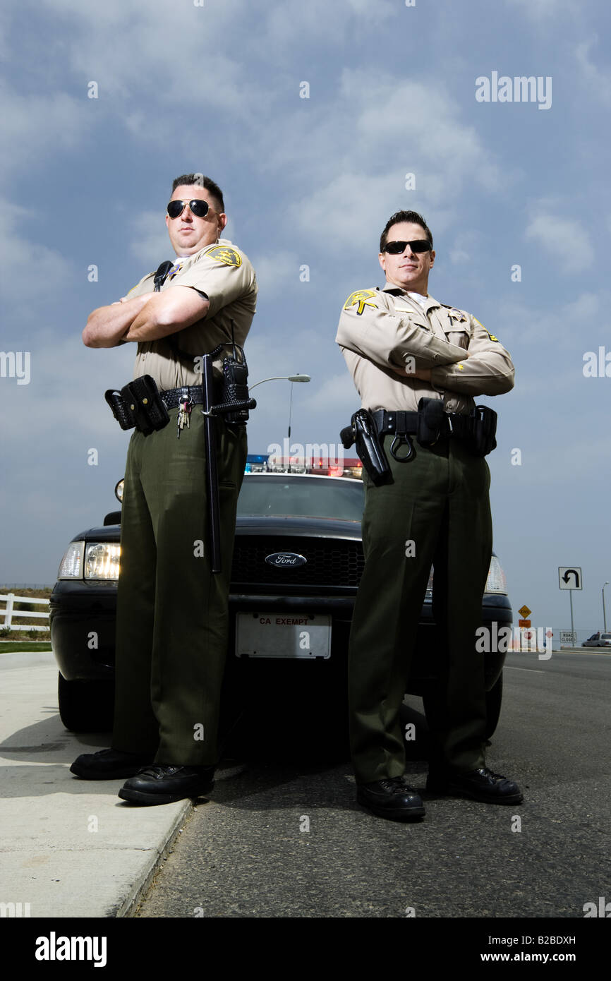 Two police officers standing in front of police car Stock Photo - Alamy