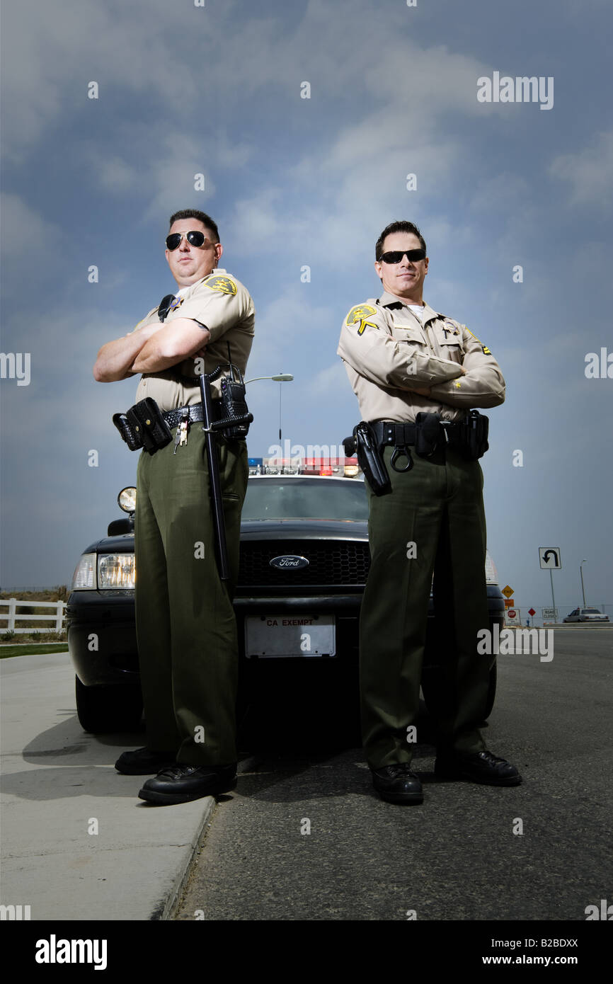 Two police officers standing in front of police car Stock Photo - Alamy
