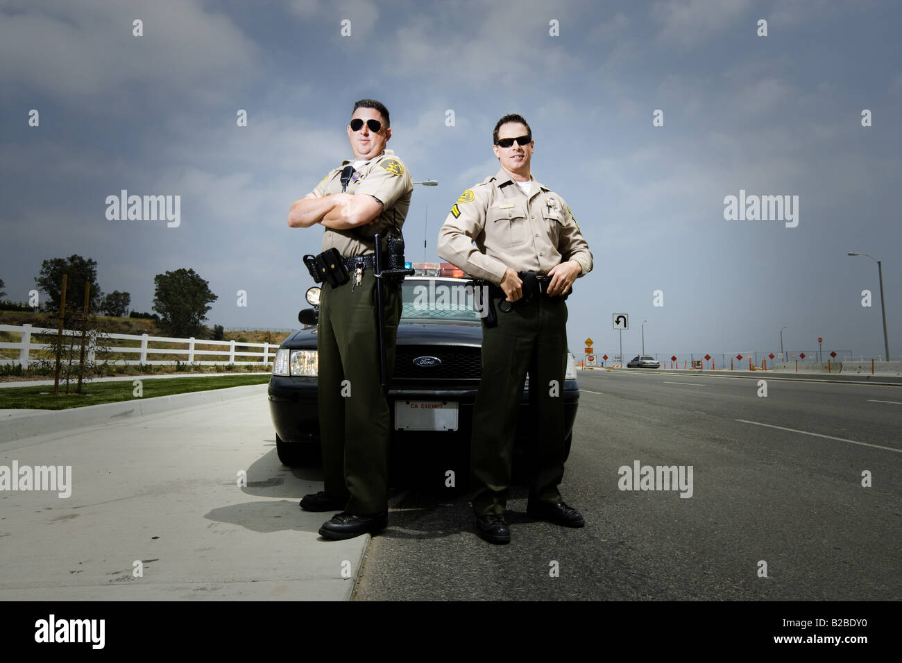 Two police officers standing in front of police car Stock Photo - Alamy