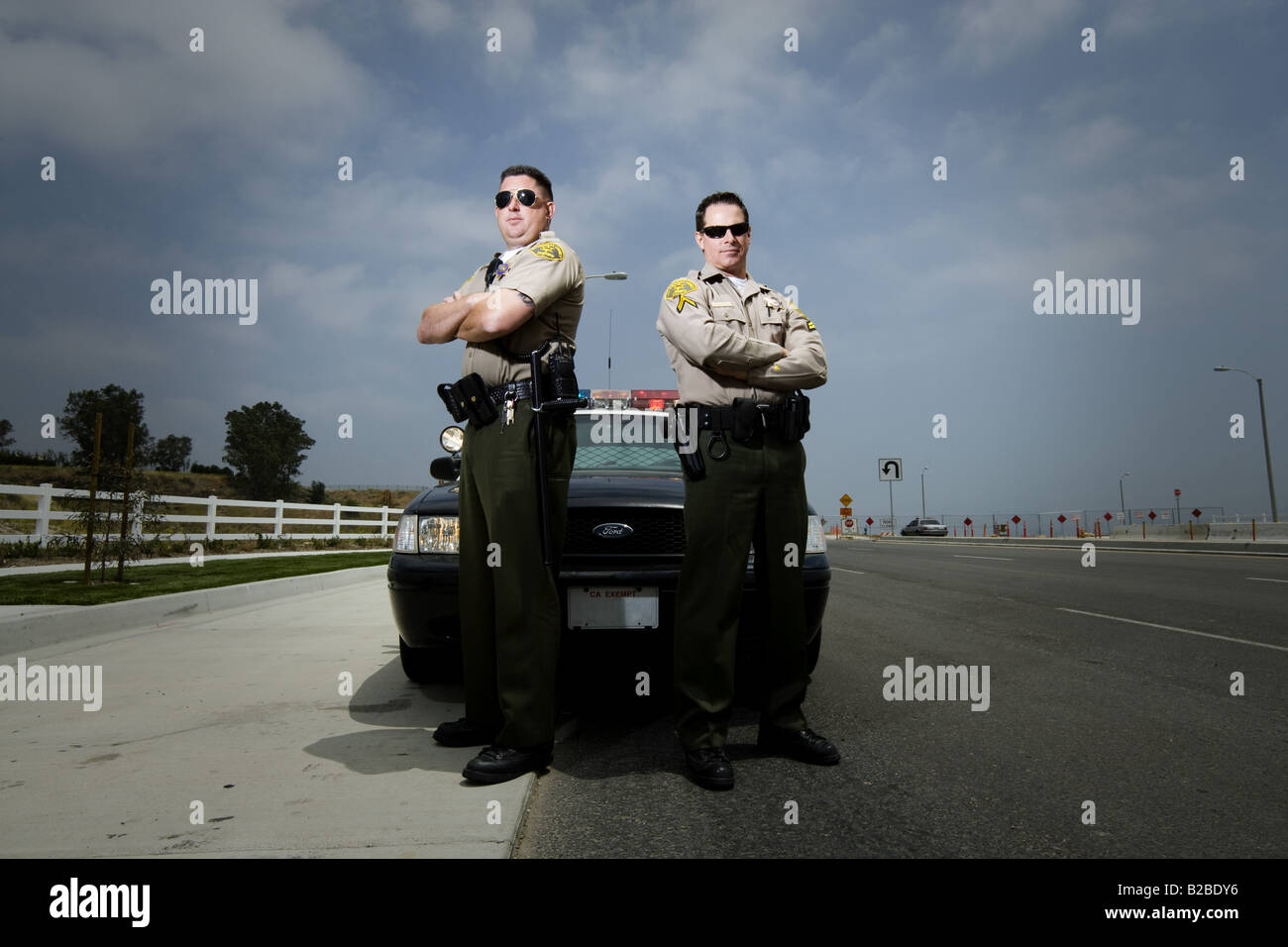 Two police officers standing in front of police car Stock Photo - Alamy