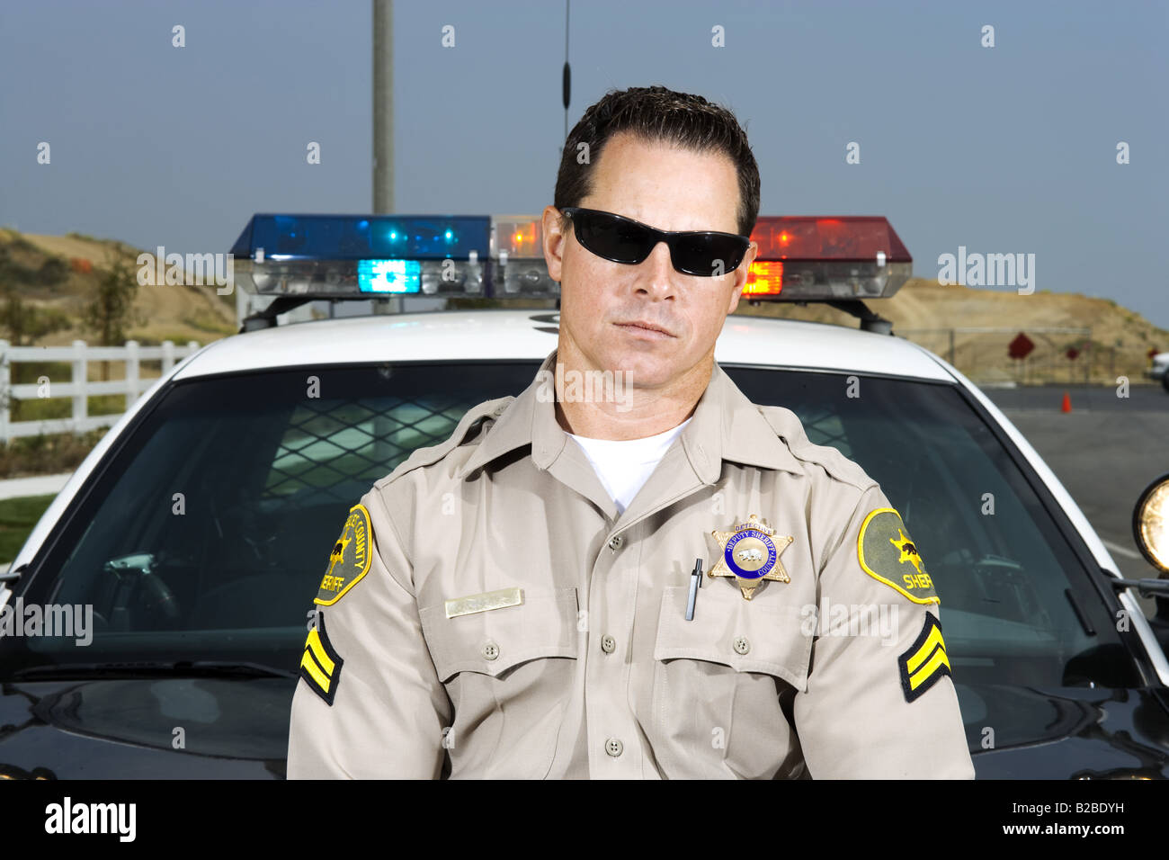 Police officer standing in front of police car Stock Photo - Alamy