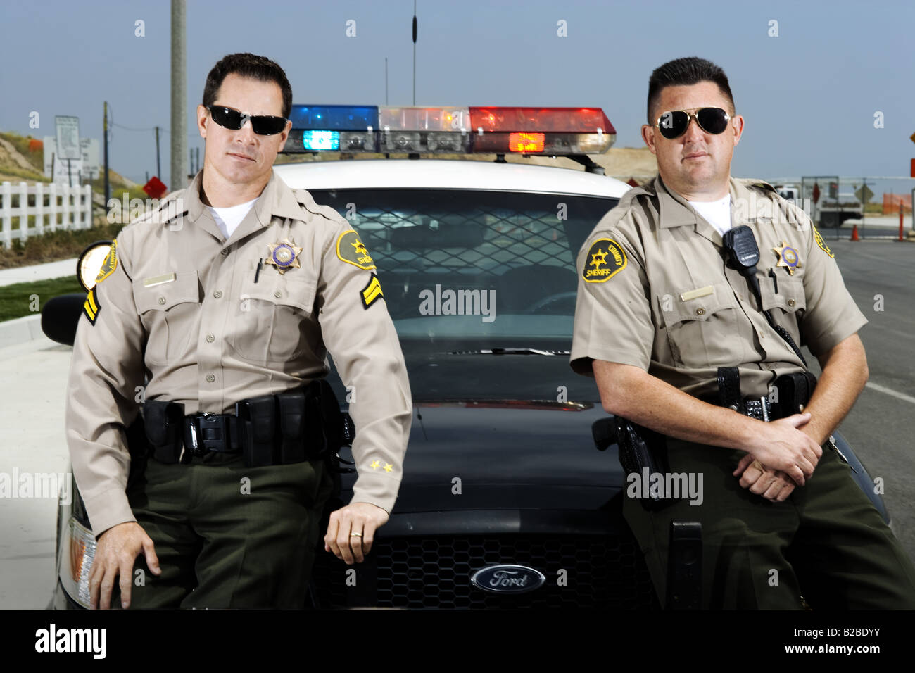 Two police officers standing in front of police car Stock Photo - Alamy