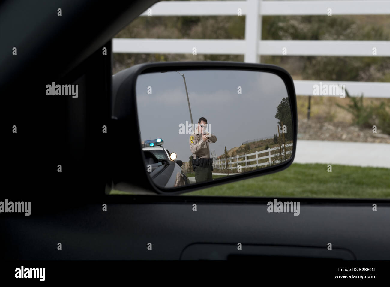 Police officer seen through side view mirror Stock Photo - Alamy