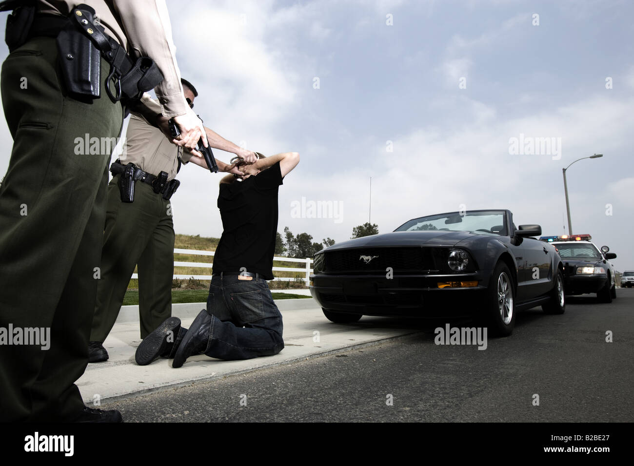 Arrested perpetrator kneeling with hands on head Stock Photo - Alamy