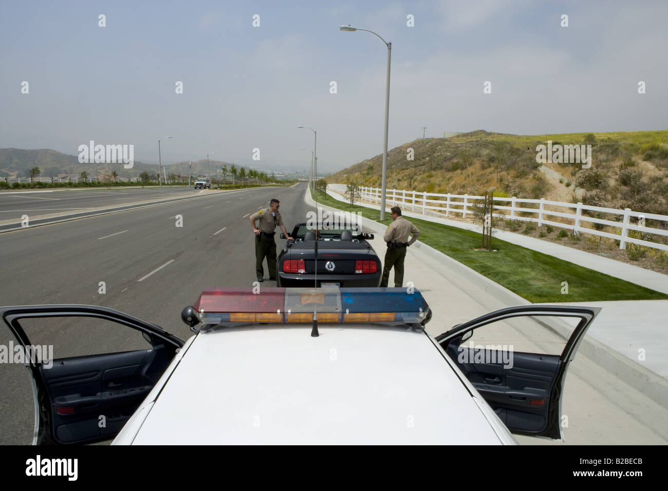 Two police officers approaching man driving Mustang Stock Photo - Alamy