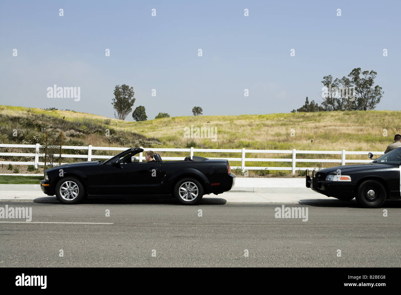 Police car and officers stopped behind man in Mustang Stock Photo - Alamy