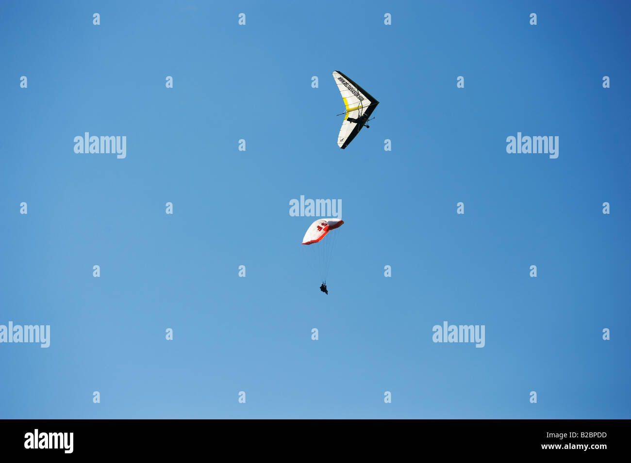 Hang glider and parascender in blue sky Stock Photo - Alamy