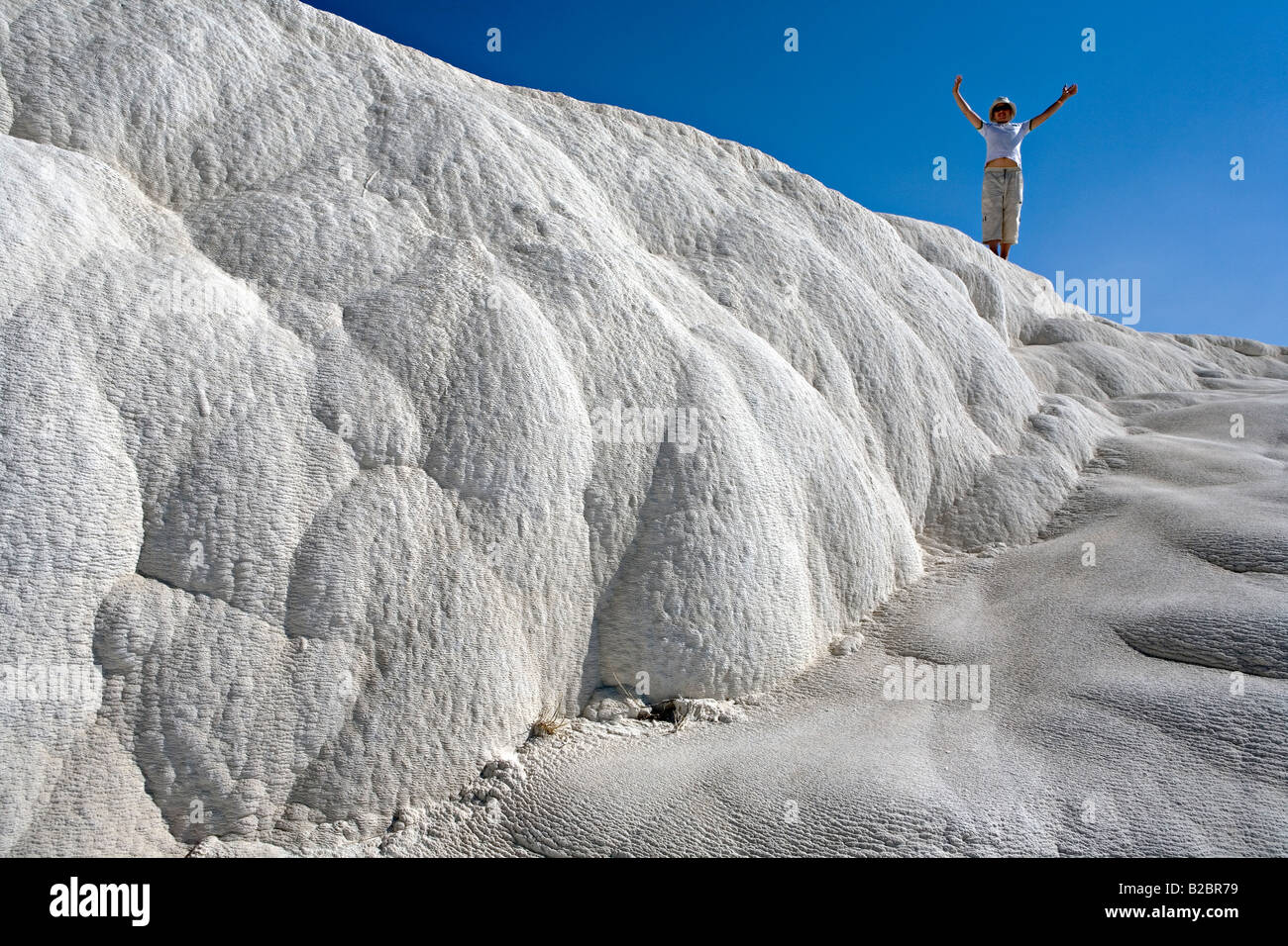 Boy standing on calcite terraces and sulphuric water pools at Pamukalle ...
