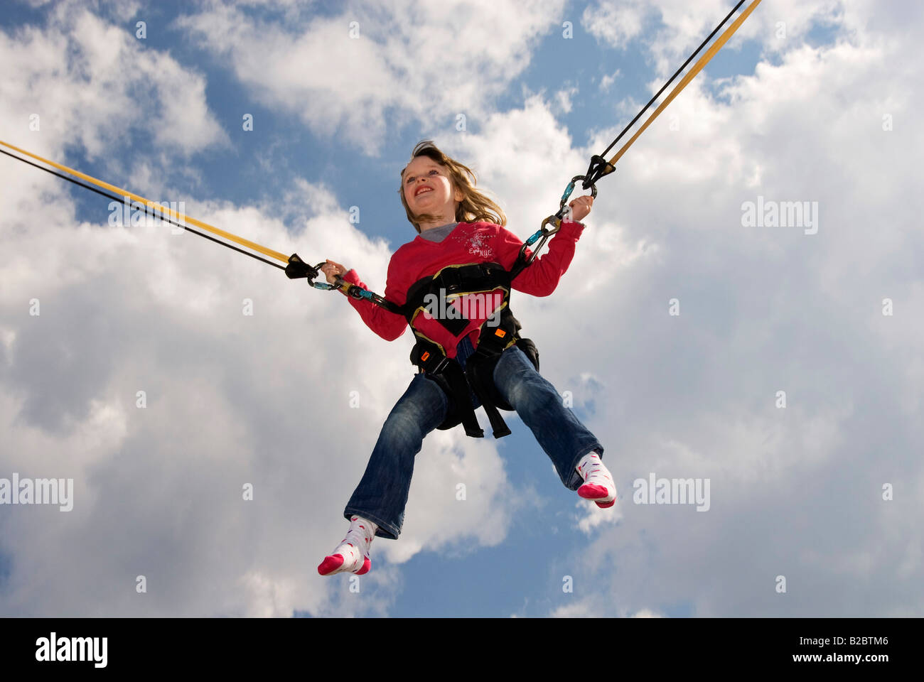 Small, 5-year-old girl jumping on a bungee trampoline Stock Photo - Alamy