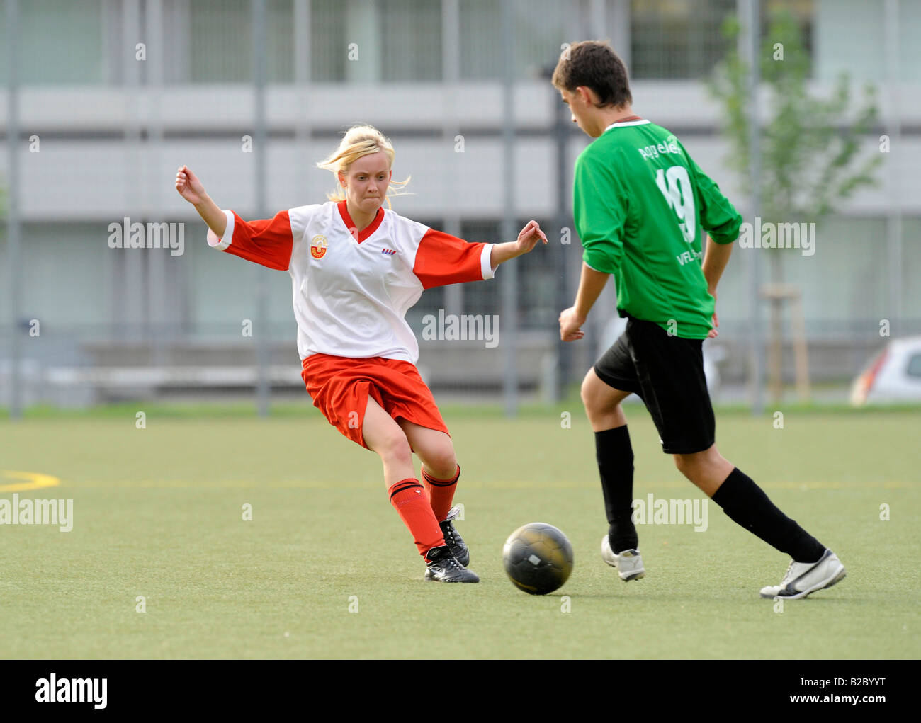 Girls playing soccer against boys Stock Photo - Alamy
