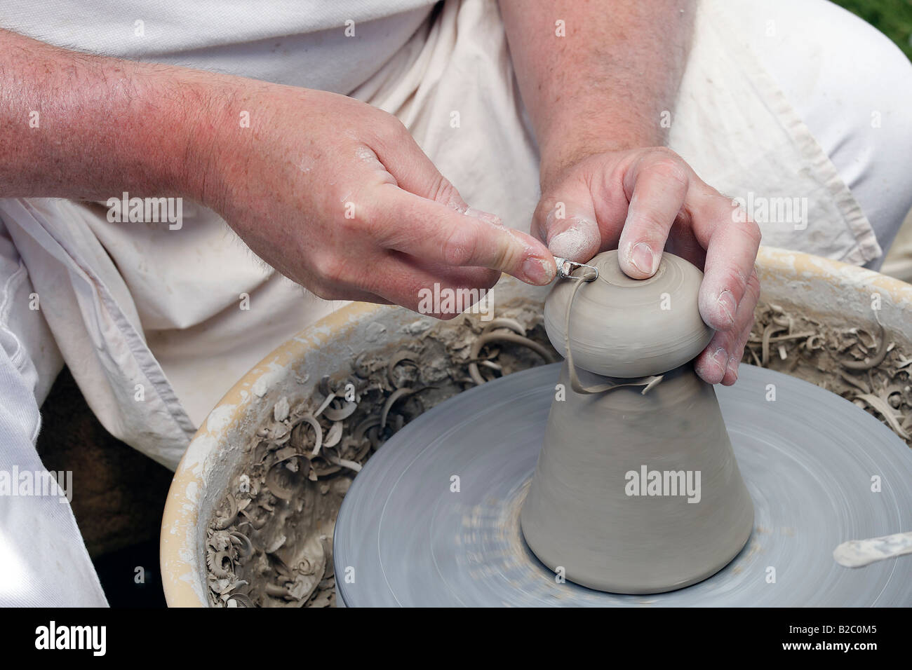Hands of a potter turning an earthenware vessel on a potters wheel ...