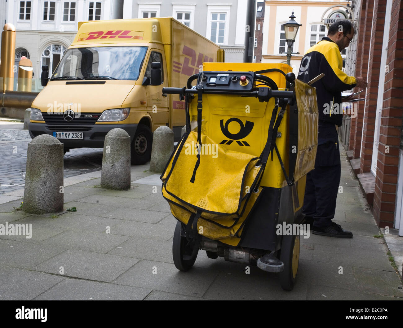Postman with his DHL motorised deliver cart in the city centre of ...