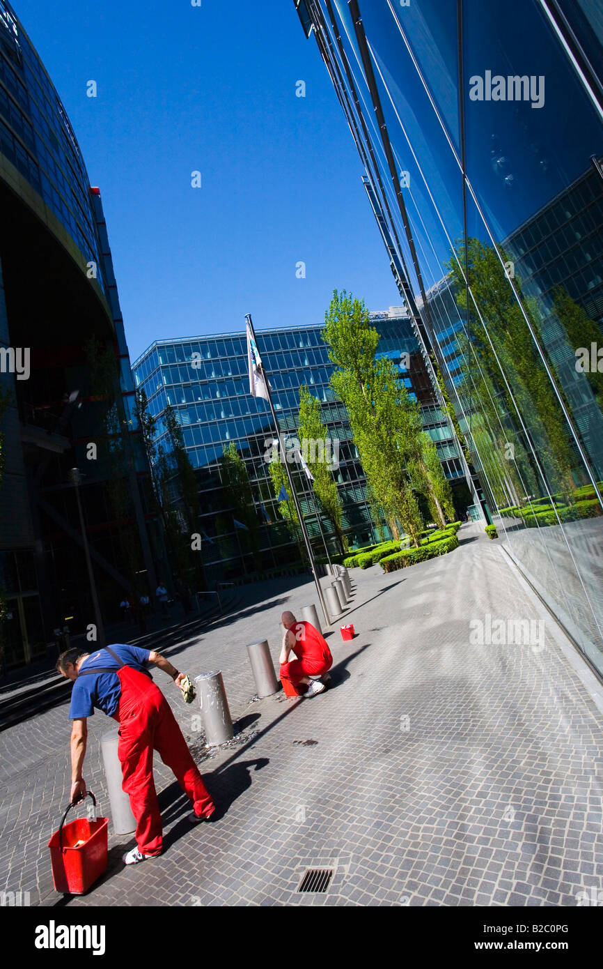 Workmen cleaning bollards, Potsdamer Platz Square, Berlin, Germany ...
