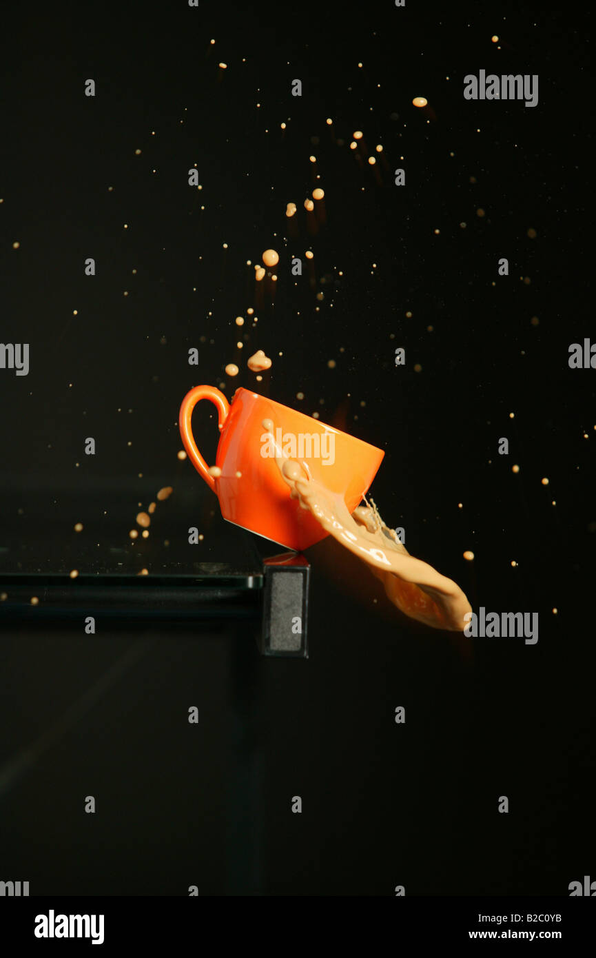 Coffee mug falling off table Stock Photo - Alamy