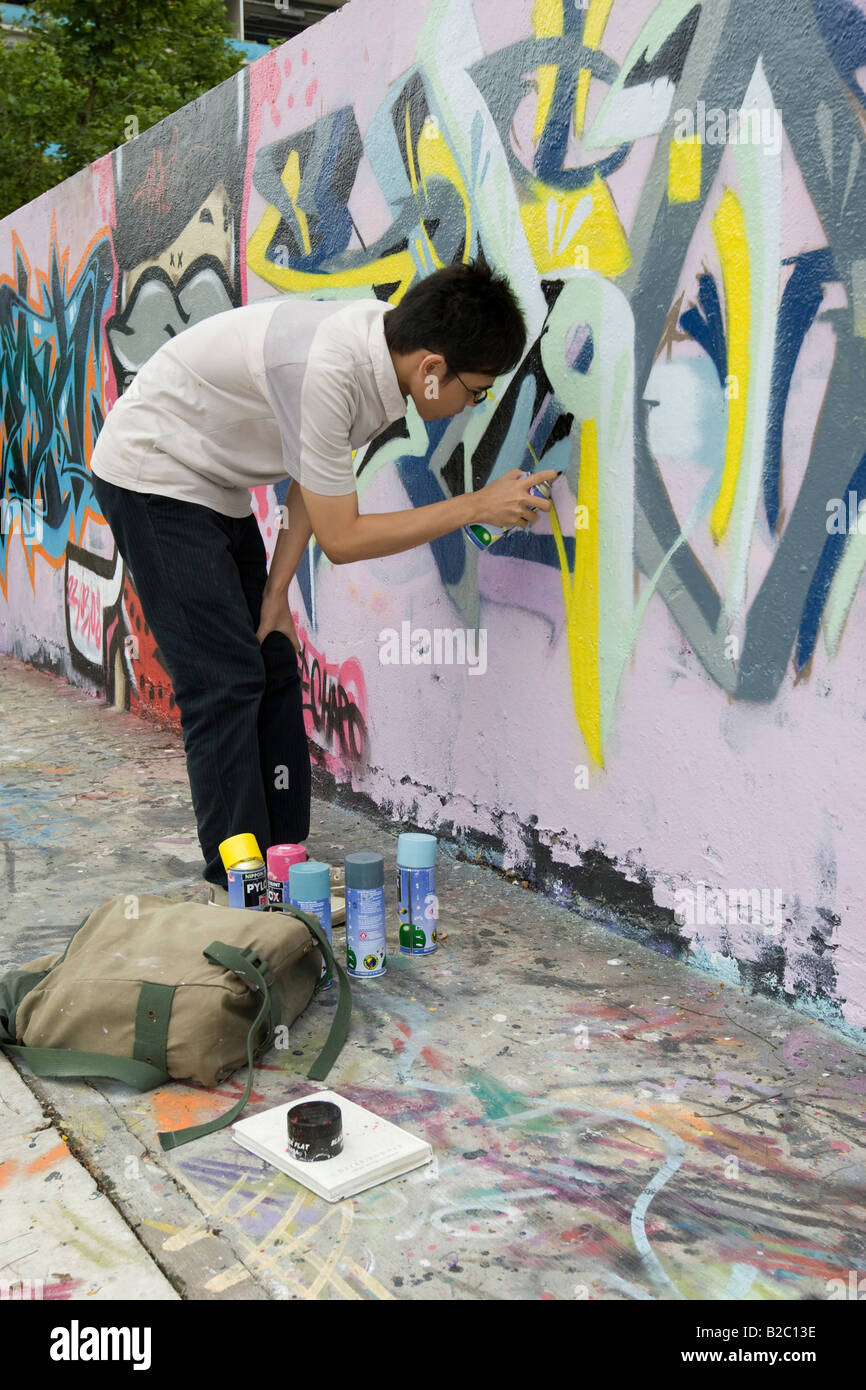 Boy spraying graffiti on a wall in Singapore, Southeast Asia Stock ...