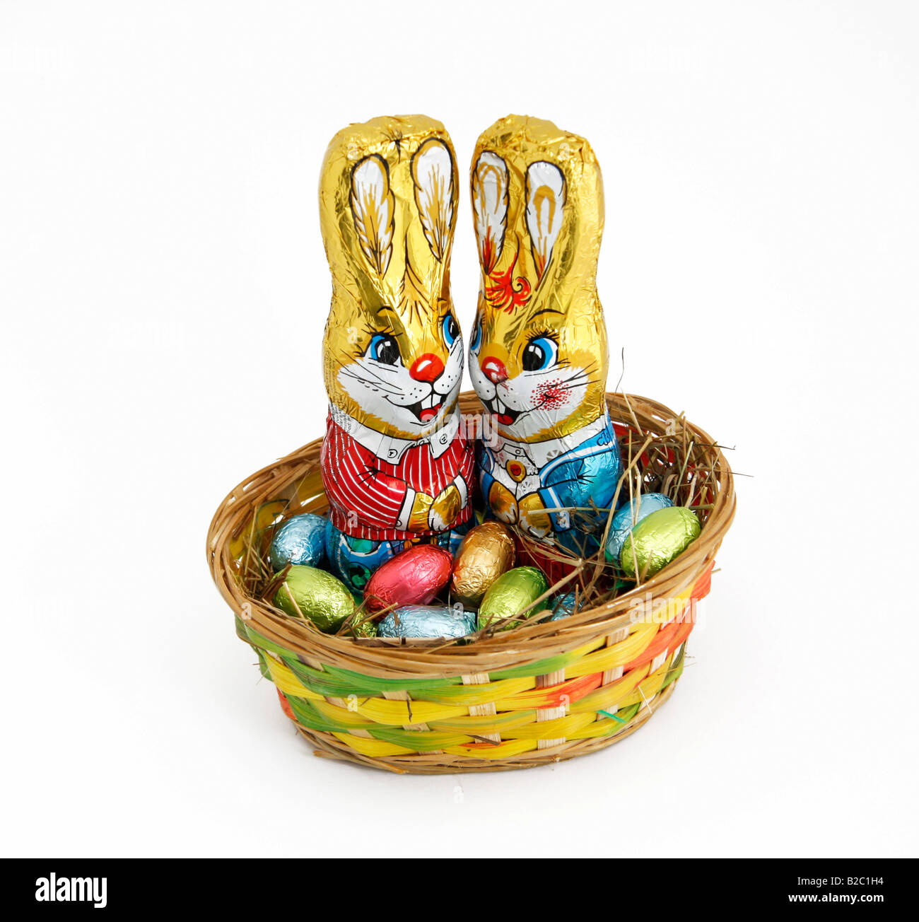 Two Easter bunnies in a basket with chocolate eggs Stock Photo - Alamy