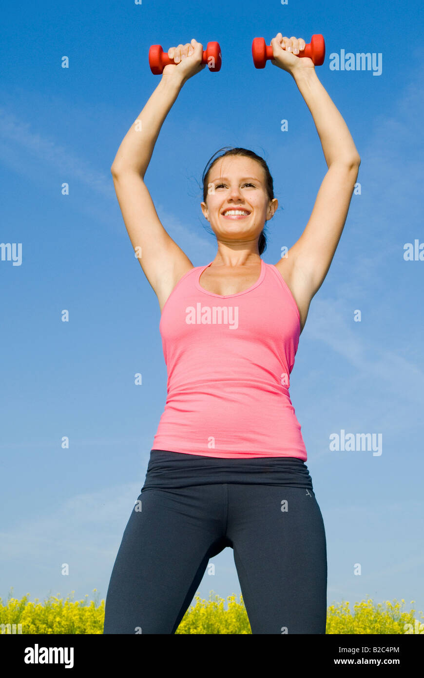 young woman lifting barbells outdoor, Cardio-Moves Stock Photo - Alamy