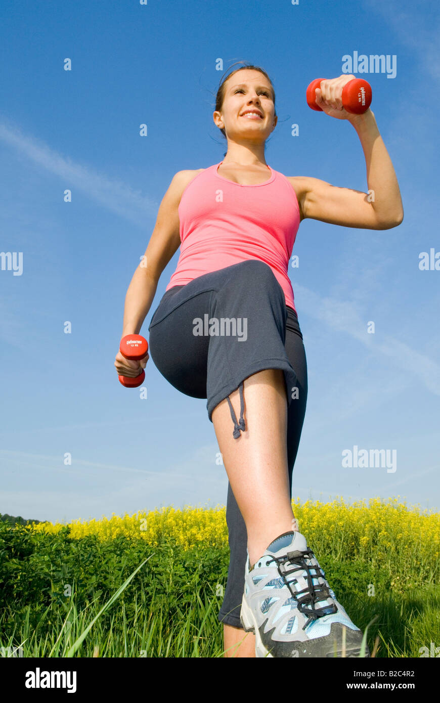 young woman lifting barbells outdoor, Cardio-Moves Stock Photo - Alamy