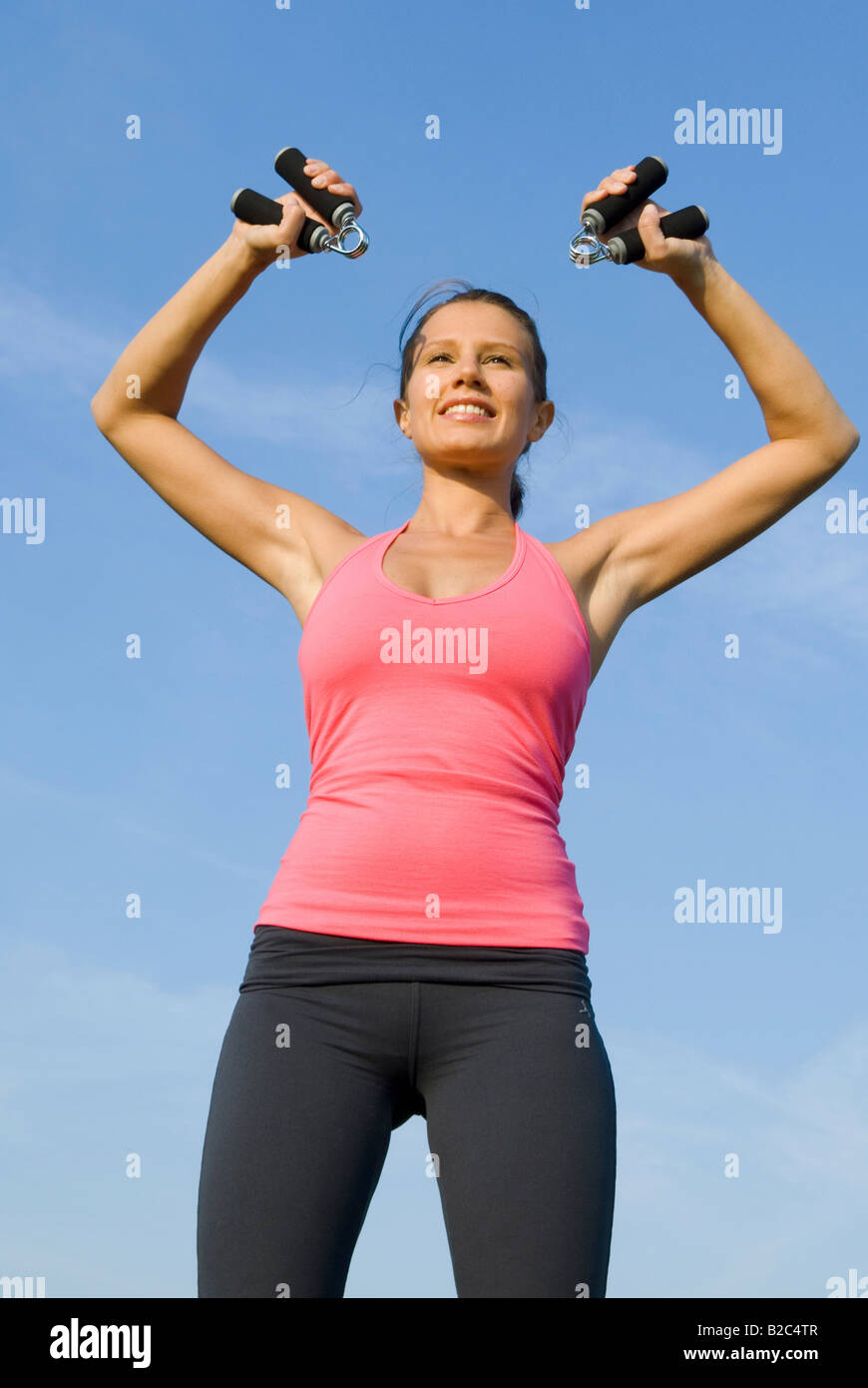 young woman exercising with handgrips Stock Photo - Alamy