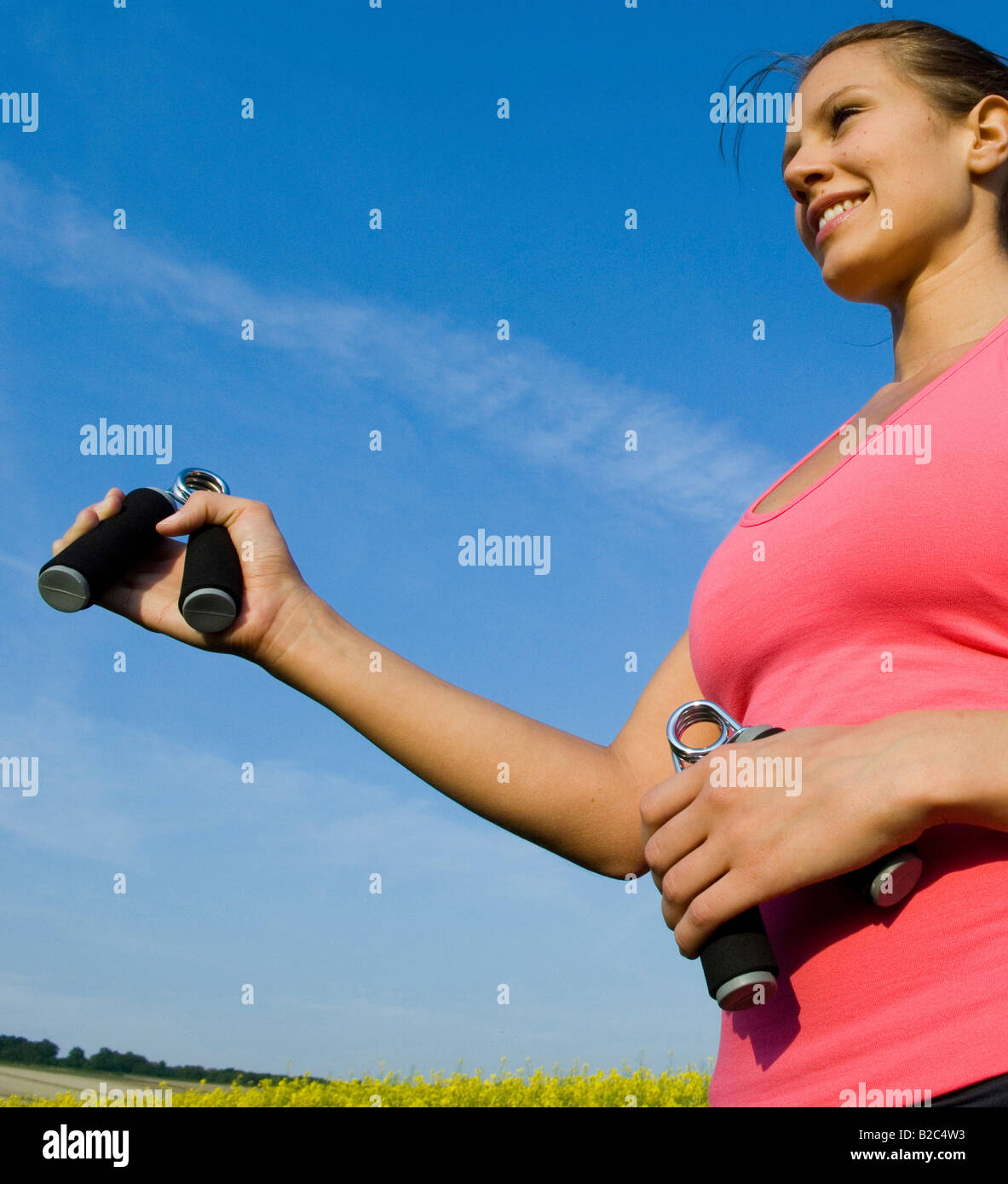 young woman exercising with handgrips Stock Photo - Alamy