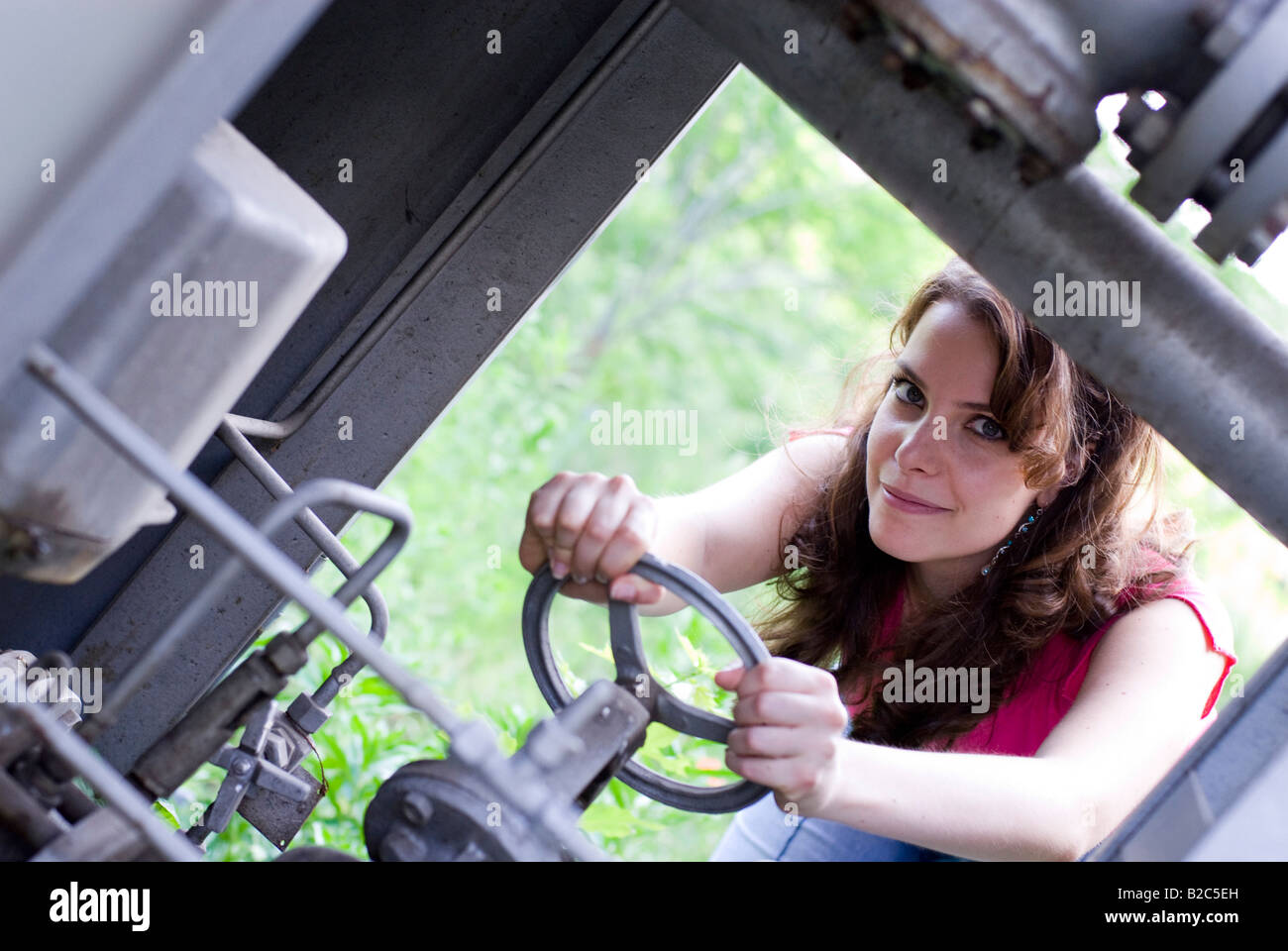 young woman with pink top turning a wheel Stock Photo - Alamy