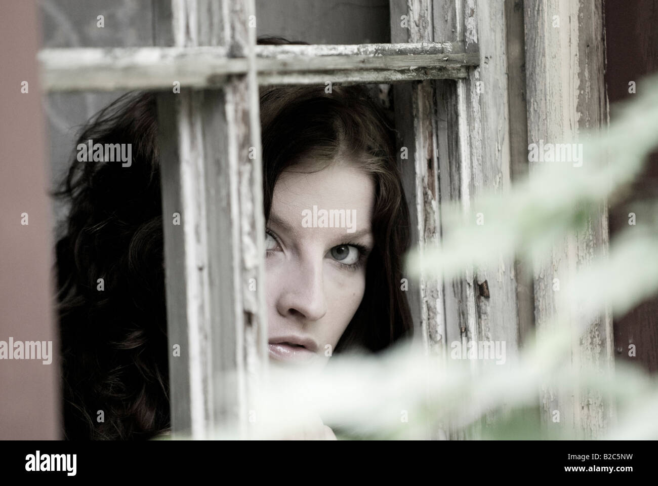young woman looking out of a window longingly Stock Photo - Alamy