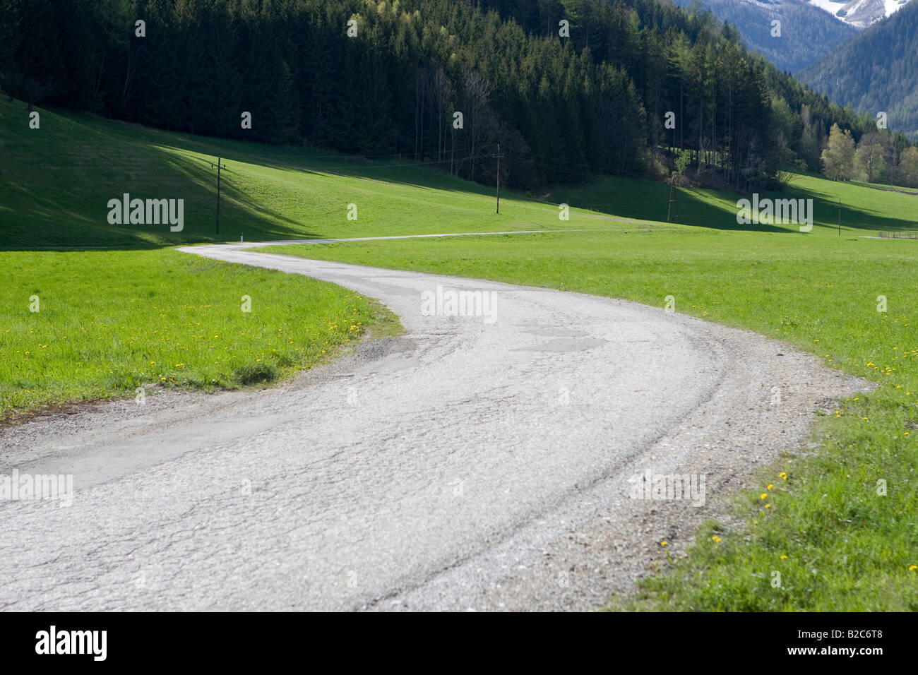S-shaped road along a meadow and between mountains Stock Photo - Alamy