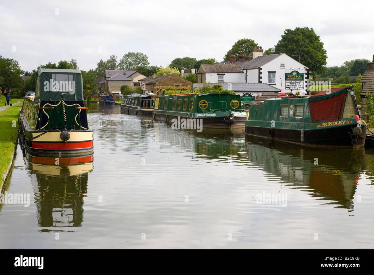 Colourful houseboats moored along canal banks at Bilsborrow Moorings ...