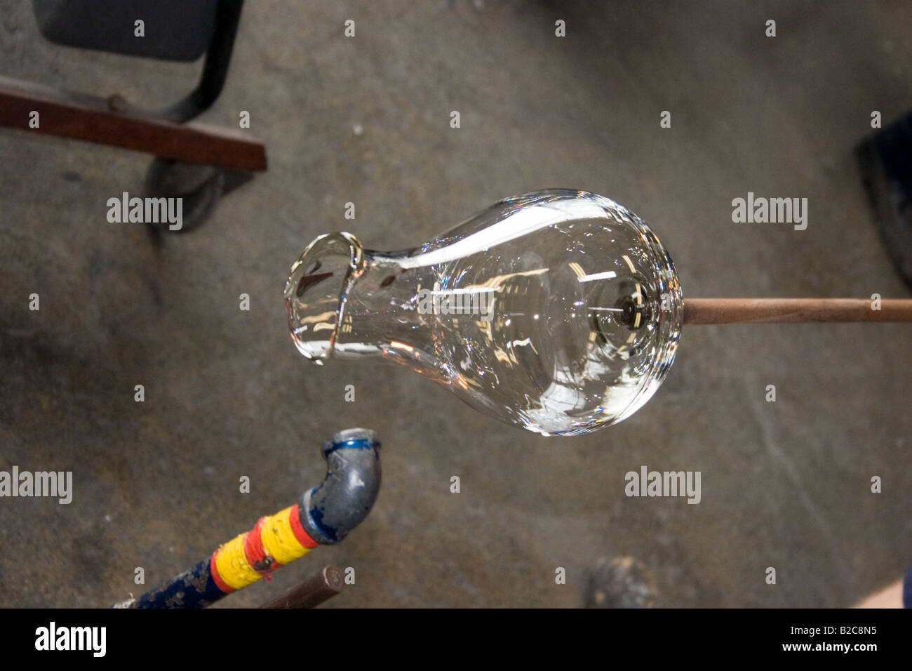 Craftman forming melting hot glass - vase with hot air . Glass blower ...