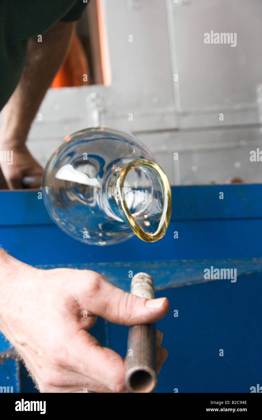 Craftman forming melting hot glass - vase with pipe. Glass blower ...