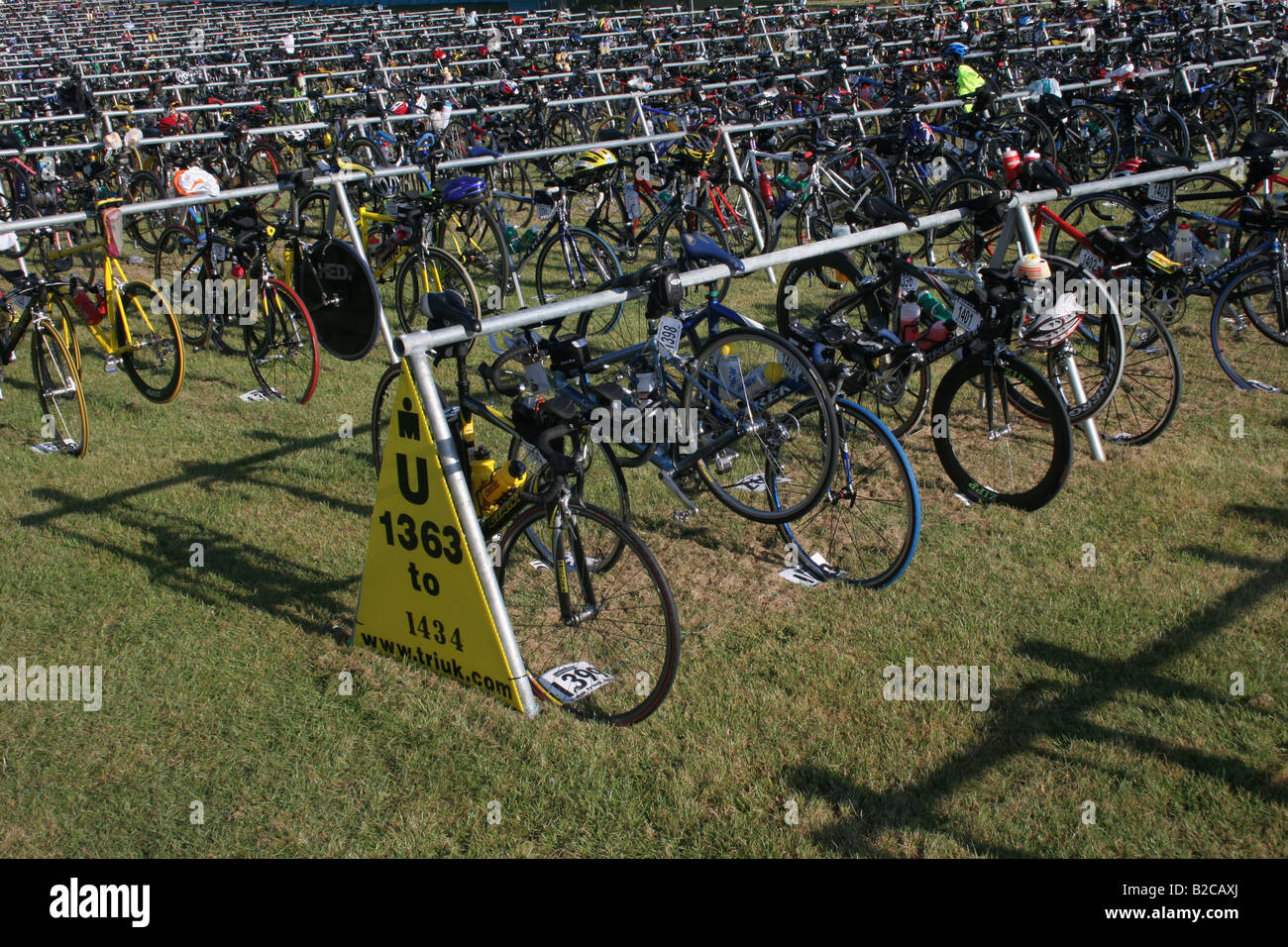 racing bycicles push bykes on transition at Ironman competition in ...